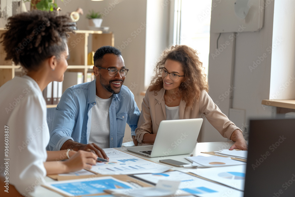 Professionals in a bright office analyze charts and data on laptops ...