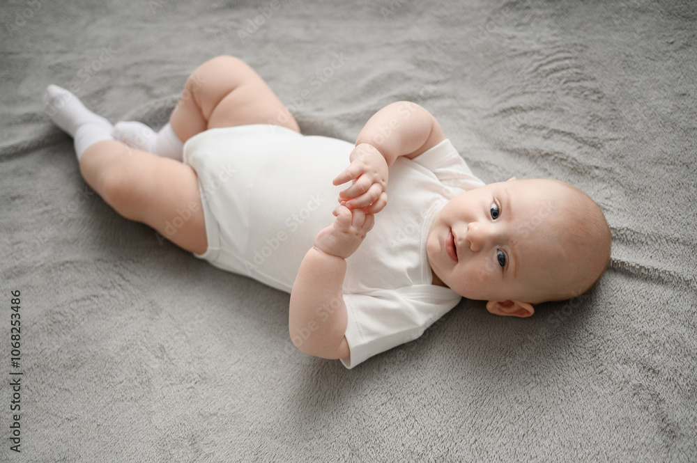 Active cute newborn baby lying on back in crib, showing emotions ...