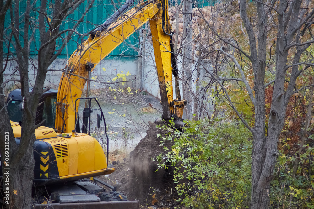 Excavator with bucket full of earth is working on a new construction ...