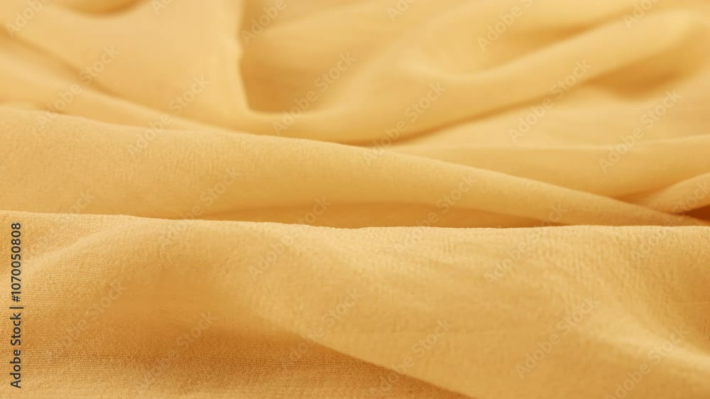 Close-up view of the soft folds of thin sepia yellow color chiffon ...