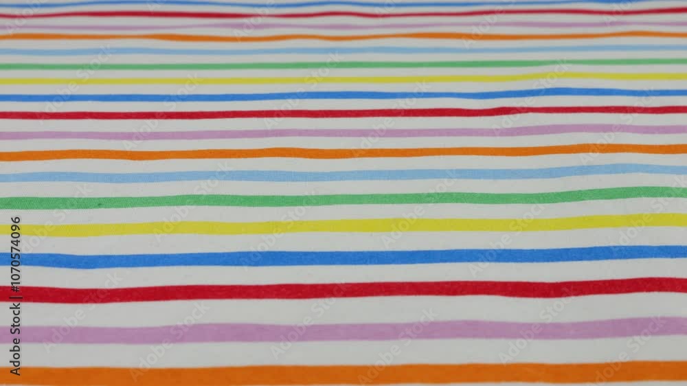 Top view of white cotton fabric with rainbow stripes rotated on the ...