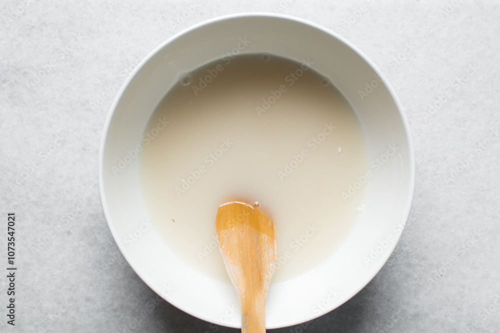 Overhead view of Instant dry yeast sprinkled on warm water, top view of ...