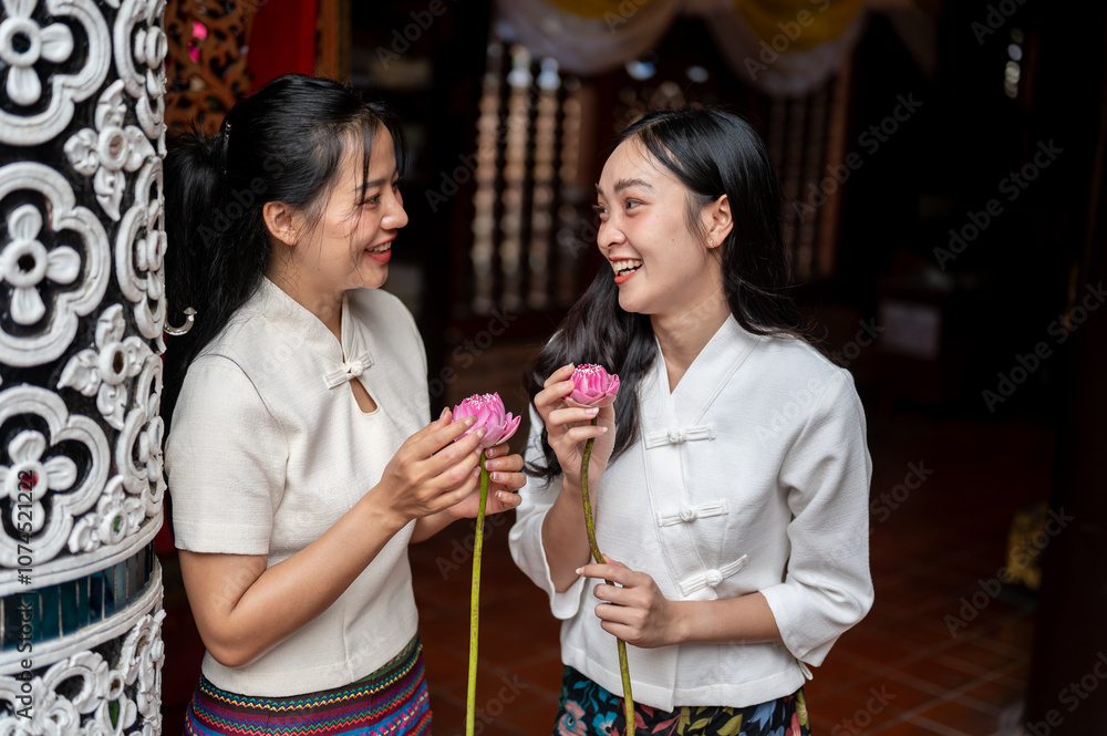 Beautiful Asian women in traditional dresses enjoy a conversation while ...
