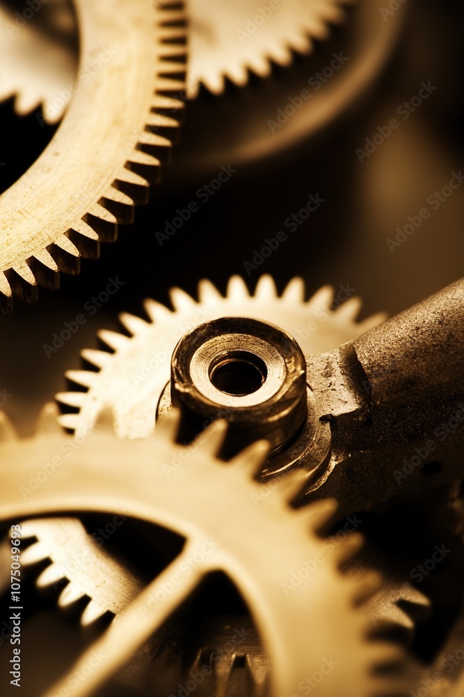 A macro photograph of intricate clock gears and cogs interlocking ...