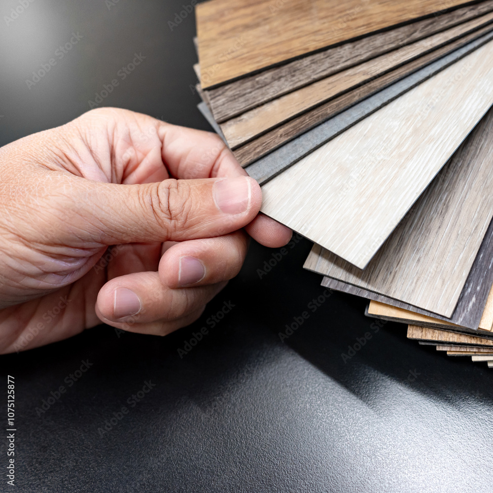 Designer hand picking sample of wood laminated material from natural ...