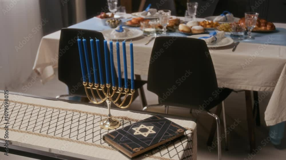 Hanukkah menorah with blue candles and Hebrew Bible placed on side ...