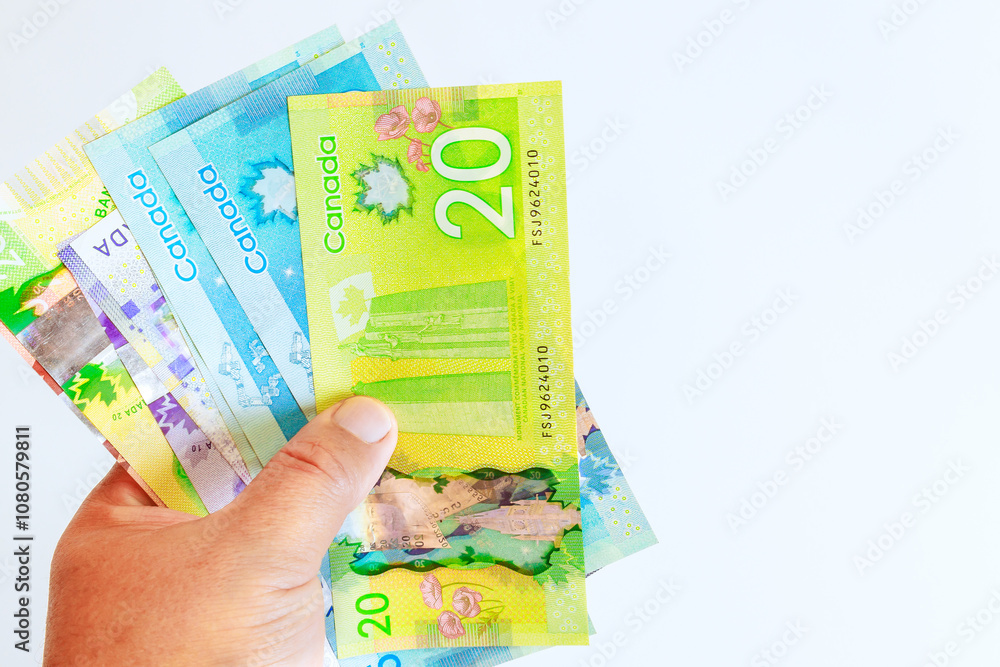 Hand of person holding Canadian money dollar bills at various ...