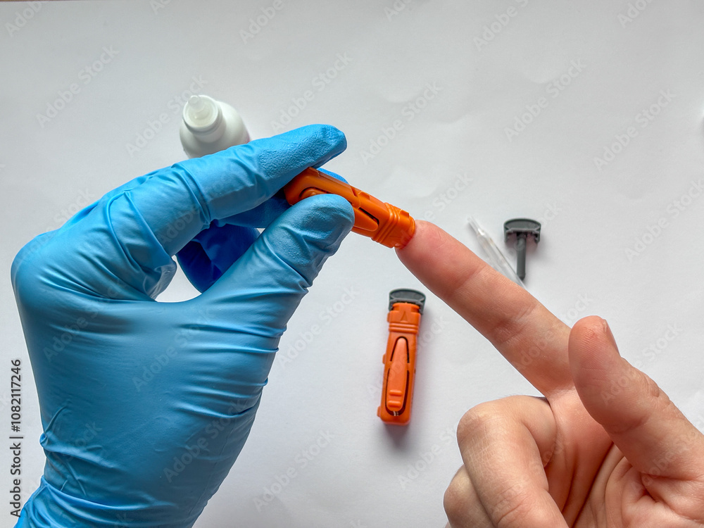 medical professional using a lancet to collect a blood sample from the ...