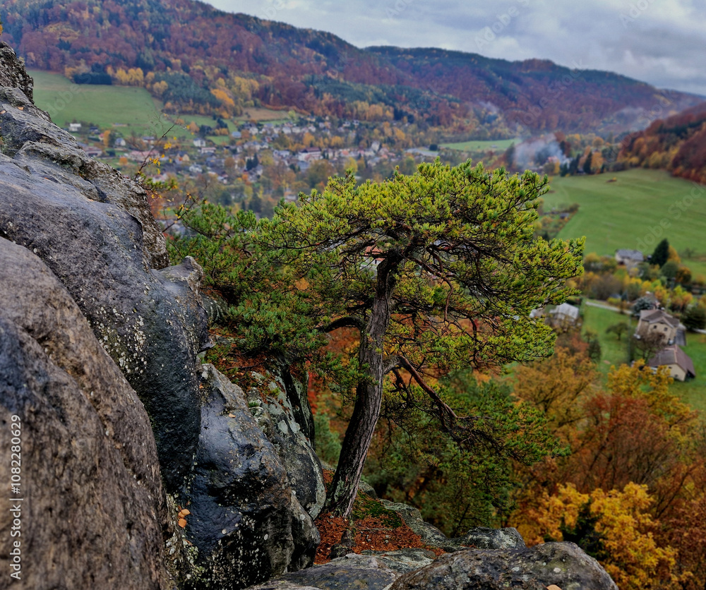 hikers walk along a narrow ridge high above autumn woods and meadows ...