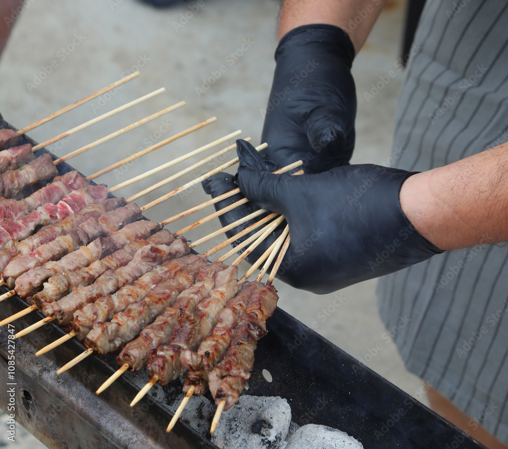 hands of the cook turning skewers of sheep and mutton meat called ...