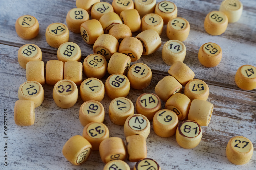 Bingo tokens scattered on an old worn surface of a table close-up, home ...