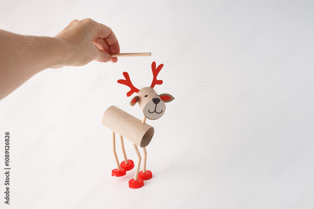 Hand holding DIY reindeer puppet made from cardboard tubes, plastic ...