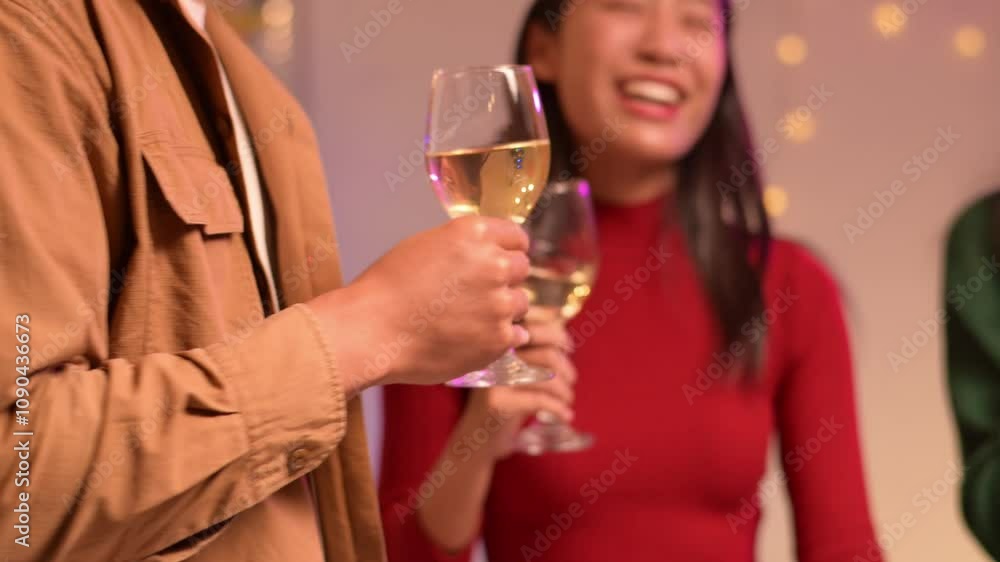 A group of people are standing around a table with glasses of wine. One ...