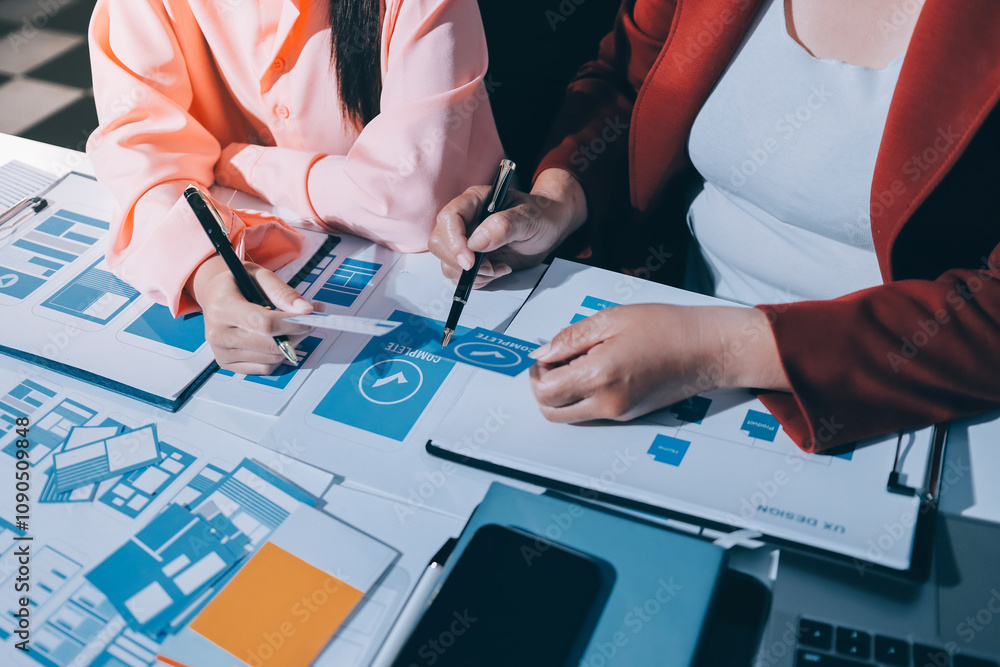 Young Asian business creative team work together, mobile application software design project ...