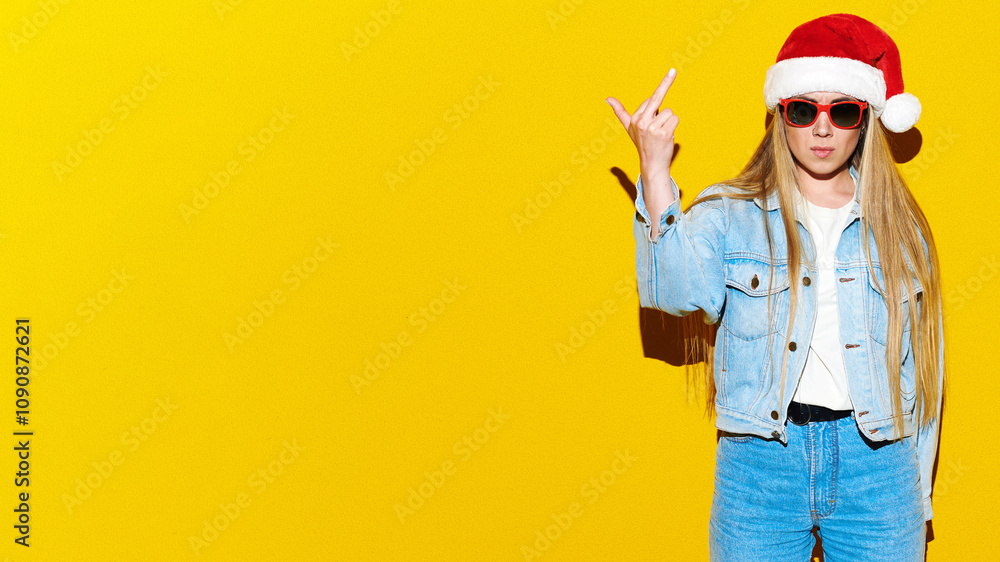 Caucasian woman in Santa Claus hat showing middle finger on yellow ...