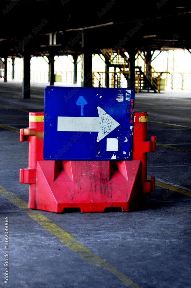 Directional arrow signs in multi storey vehicle parking areas installed on an orange road ...