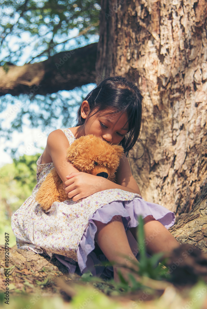 Vertical Sad girl hug teddy bear sit sadness alone in green park ...