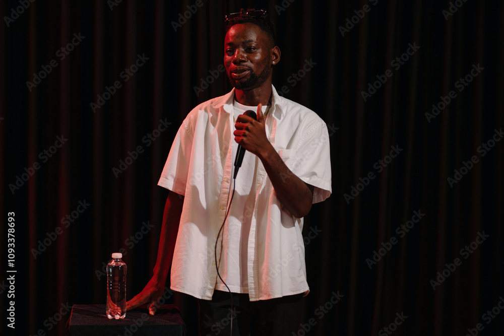 African American comedian holding microphone, performing stand-up ...