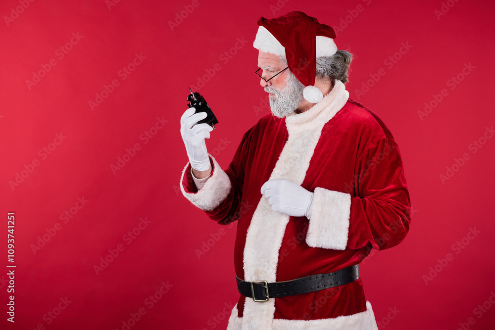 Santa Claus dressed in suit holding walkie-talkie and looking at it ...