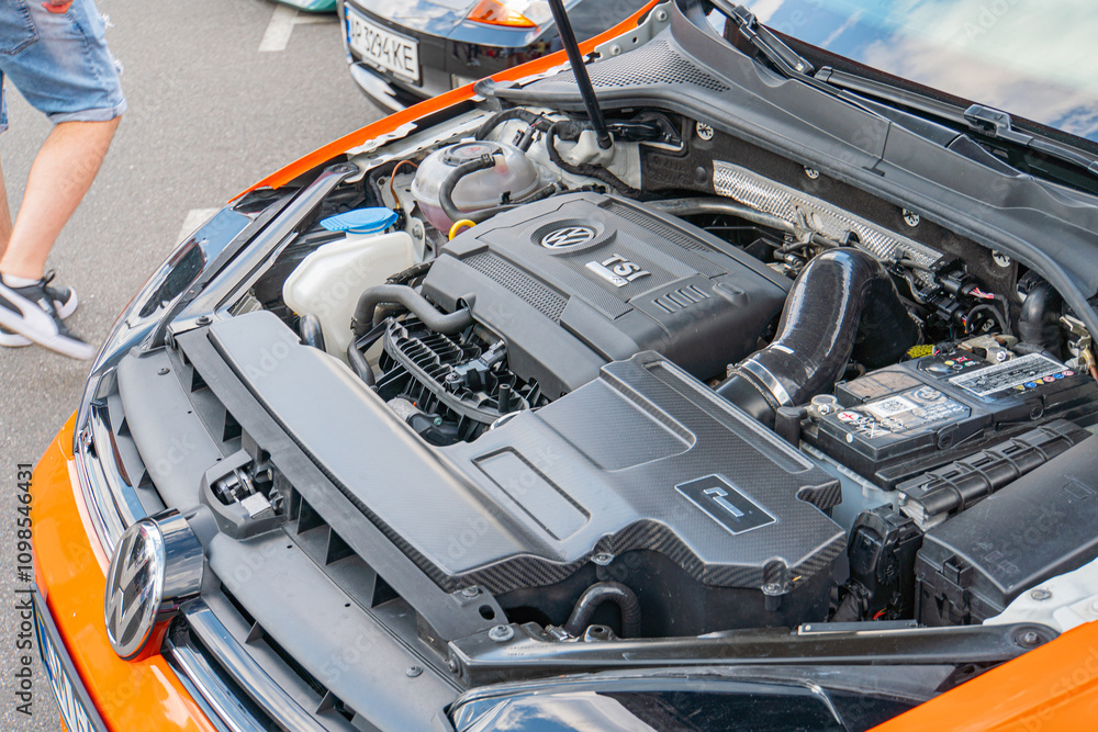 A close-up photograph of the engine bay of a car with the hood propped ...