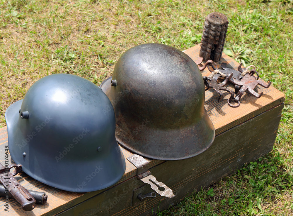 Antique war relics including a metal protective helmet and grenade used ...
