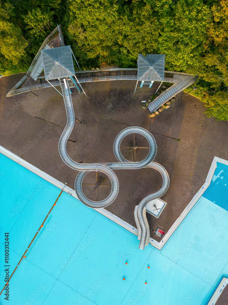 Aerial view of beautiful public pools with water slides surrounded by ...
