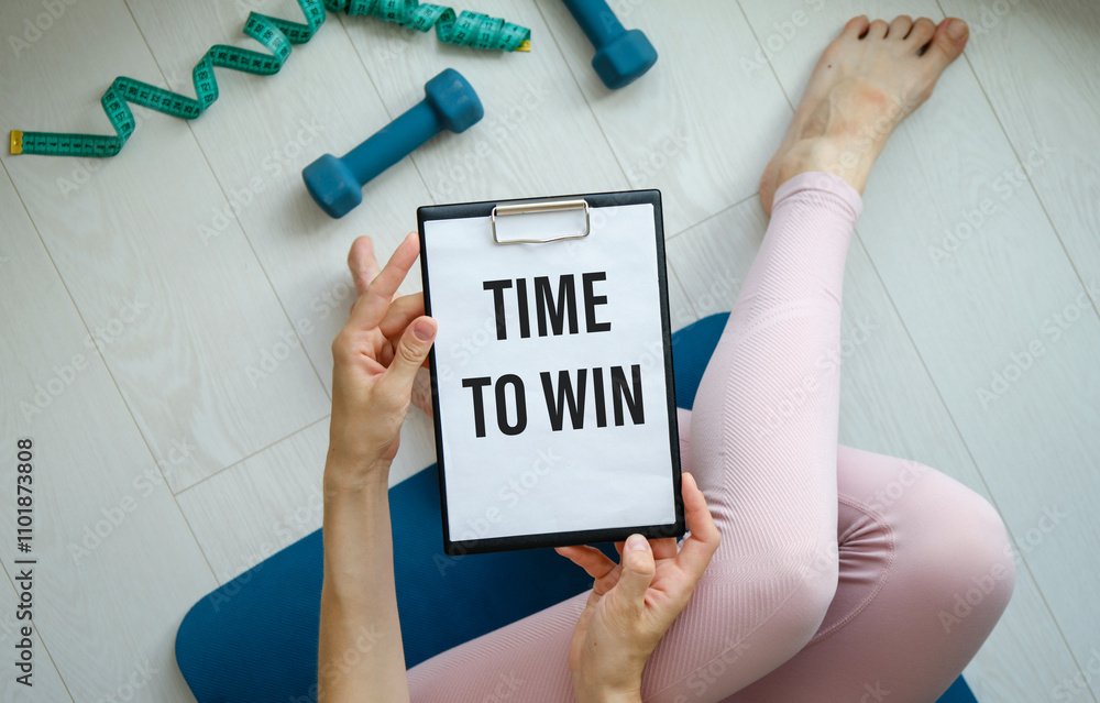 Time to win text written on a paper tablet in the hands of a girl ...