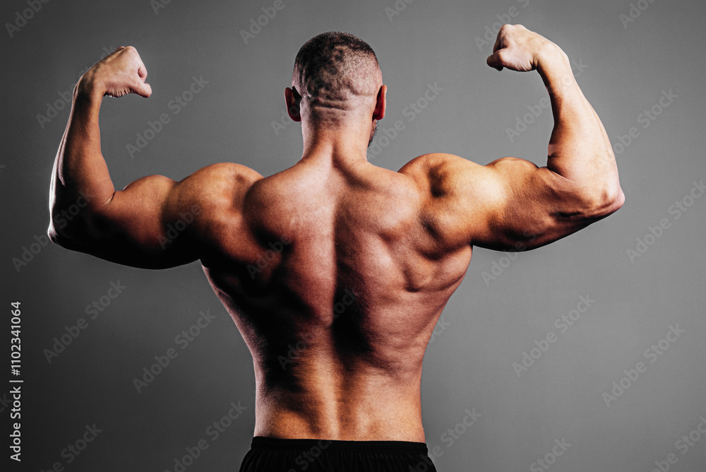 Muscular back of man flexing his arms. Back view of fitness model with ...