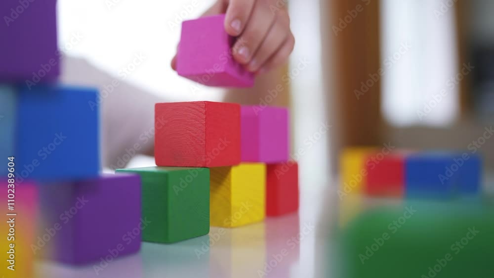 Girl daughter plays with blocks, builds. Play toddler kid concept. The ...