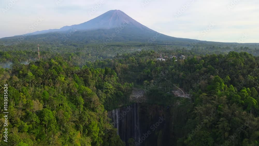 Drone panning showing tumpaksewu waterfalls in middle of thick tropical ...