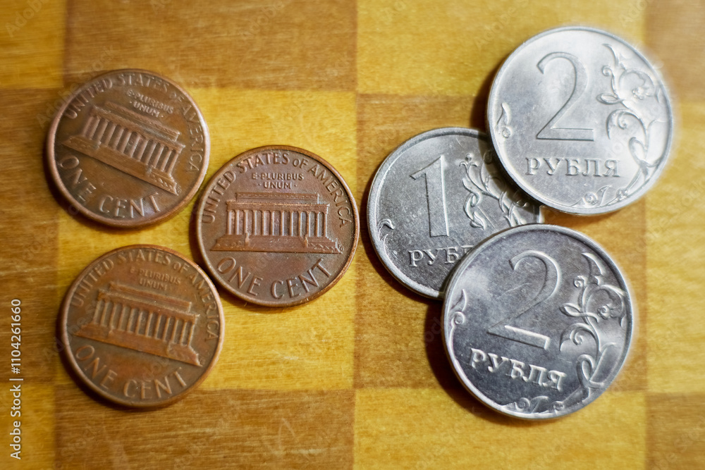 One-cent coins lie opposite one-ruble coins on a chessboard, macro shot ...
