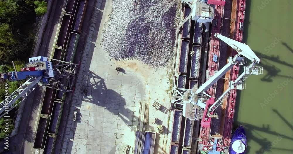A summer day. top-down view. A cargo port with several ships, a railway ...