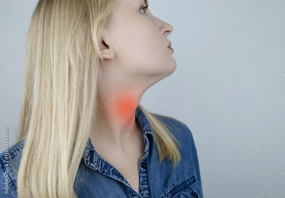 Thyroid disease. Woman points to her neck where the thyroid gland is ...