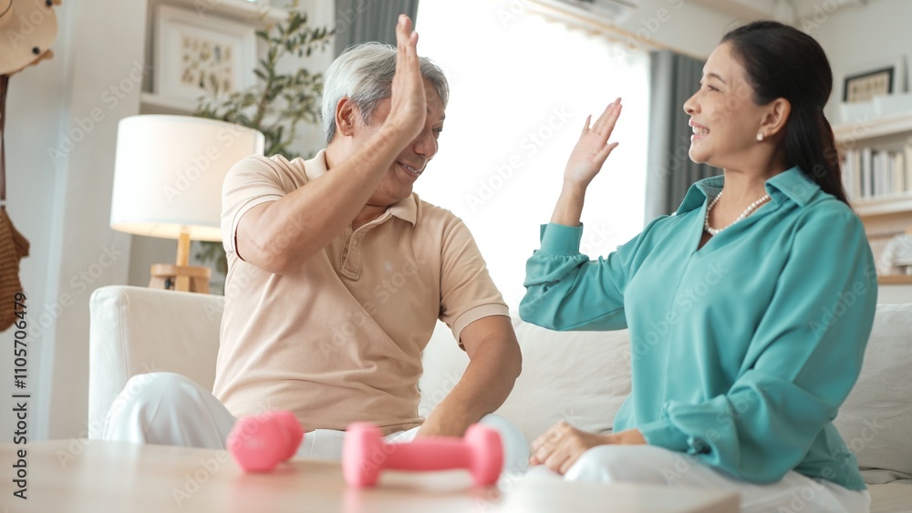 Elder woman using dumbbell at living room for boosting balance and ...