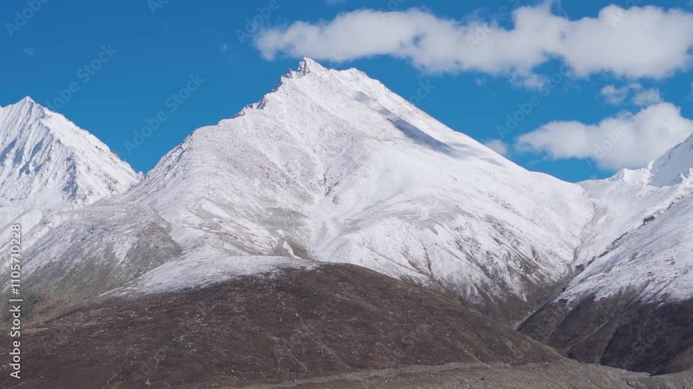 Fresh snow on the dry Himalayan mountain peaks during a sunny cloudy ...