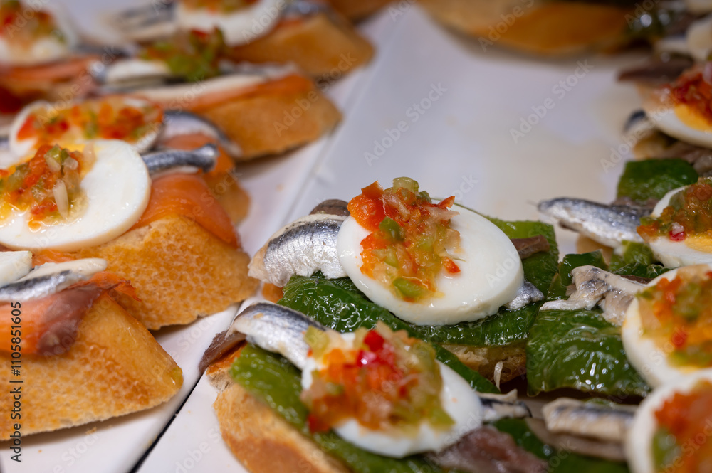 Typical snack of Basque Country, pinchos or pinxtos skewers with small ...