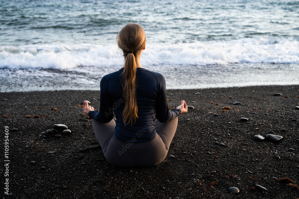Young woman doing yoga meditation outdoors. Back view of a girl ...
