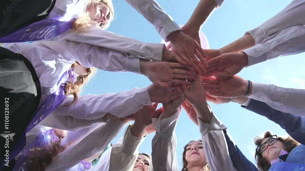 Students linking arms and holding balloons to celebrate their ...