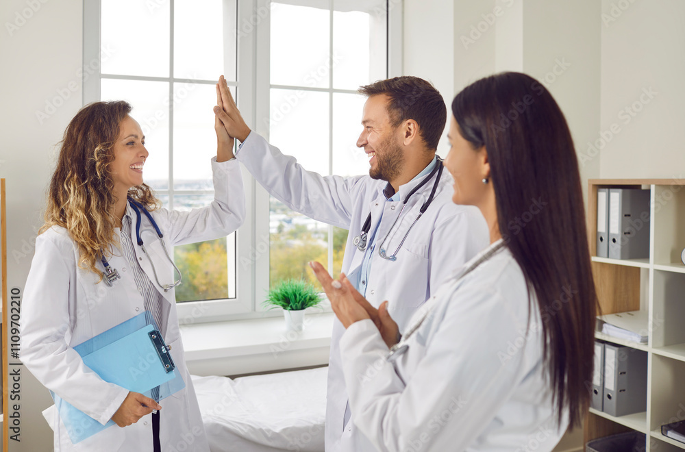Positive and diverse team of doctors and nurses giving each other high ...