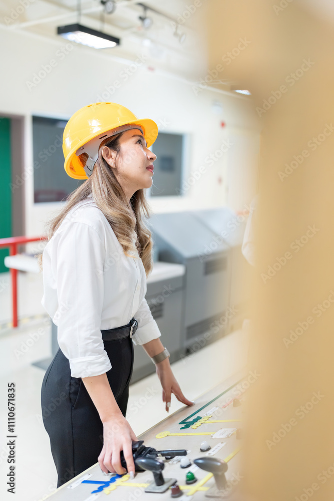 Asian female engineer standing working in the machine room of the ...