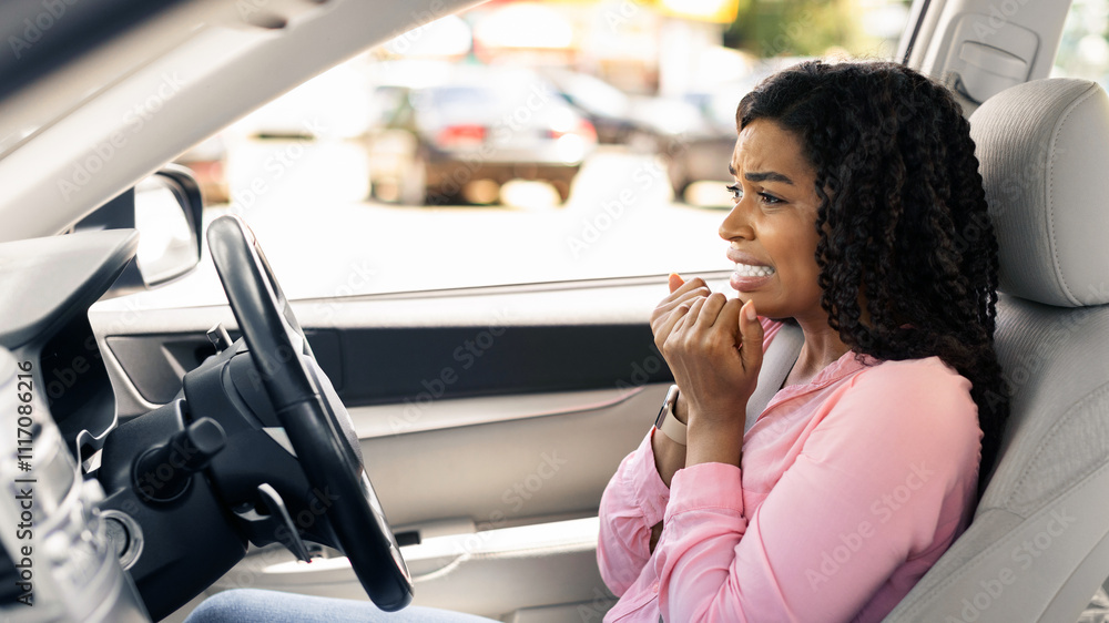 Portrait of scared African American young woman driving car on high ...