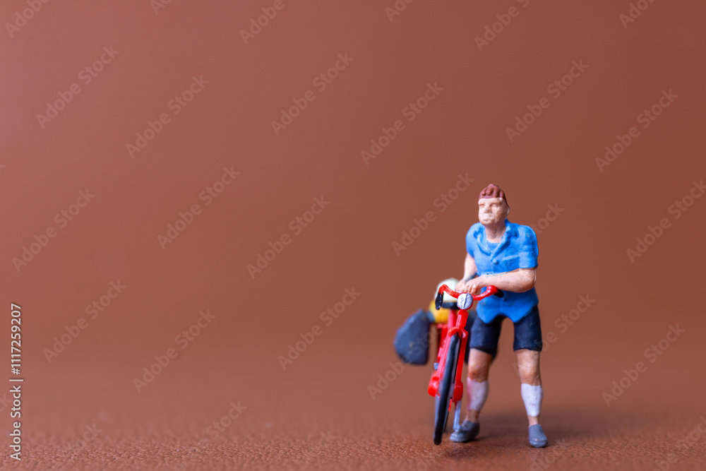 Miniature figure of a cyclist wearing a blue shirt, standing next to a ...
