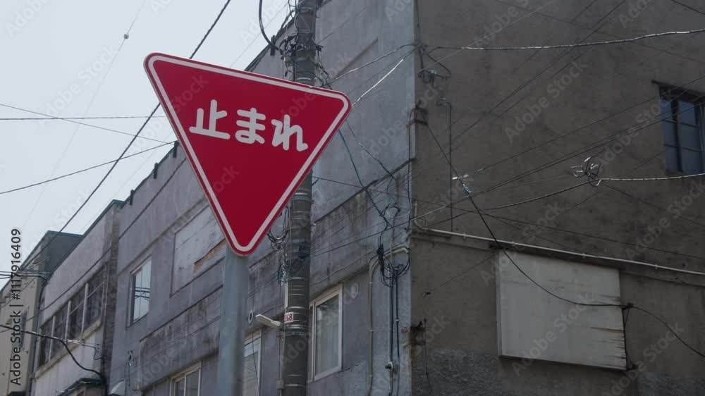 Japanese traffic sign indicating "Vehicles must stop and proceed again ...