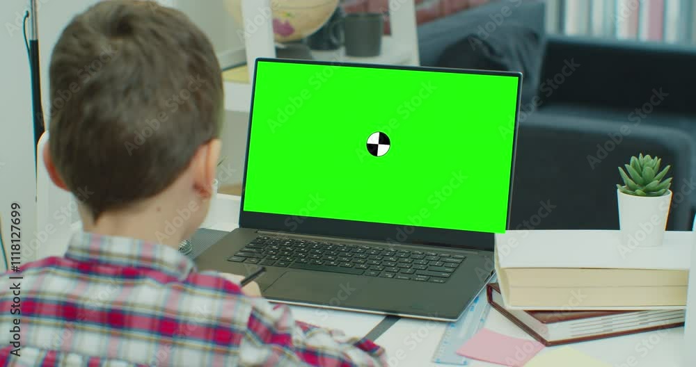 Little boy uses green screen chroma key laptop for learning, writes ...
