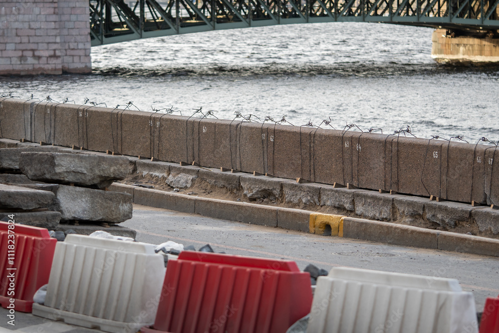 River embankment maintenance. Replacing and aligning granite slabs ...