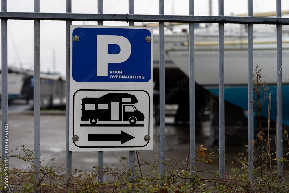 Parking sign for overnight camper van stays, displayed on a metal fence ...