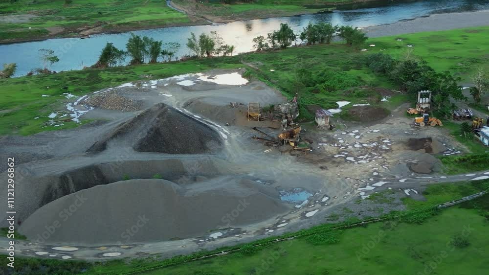 Orbiting aerial view of rock quarry and crushing site along tropical ...