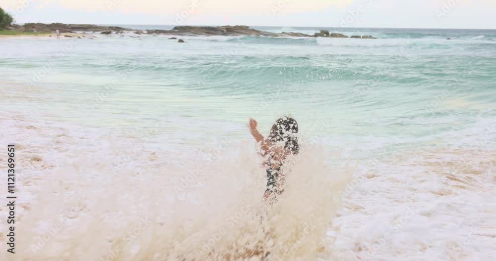 A playful moment as a woman in a black swimsuit gets knocked over by a ...