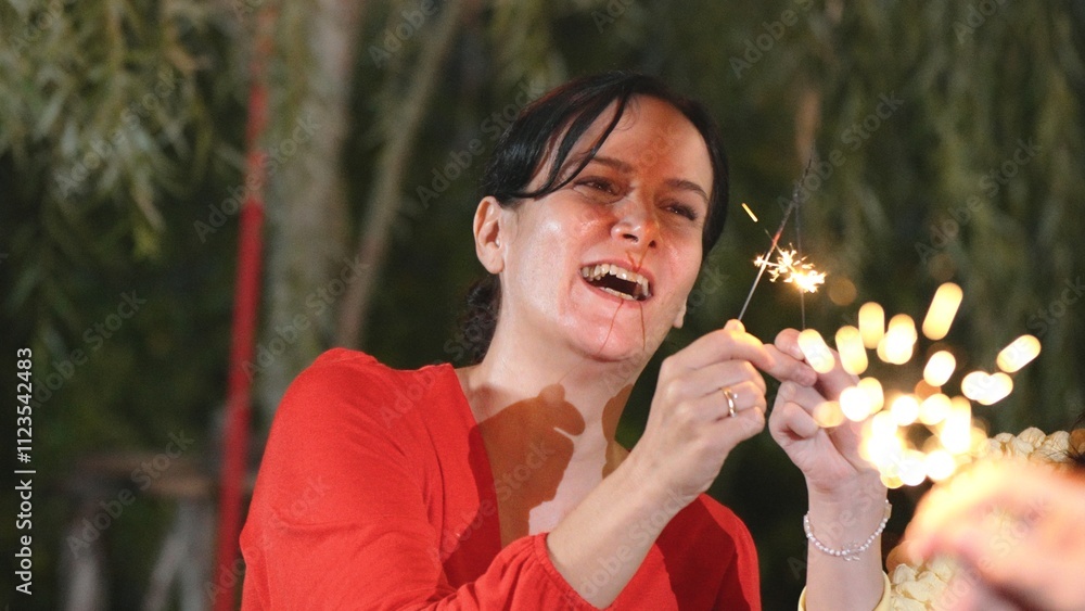Smart mature grandmother hold sparkler in holiday celebration party of ...