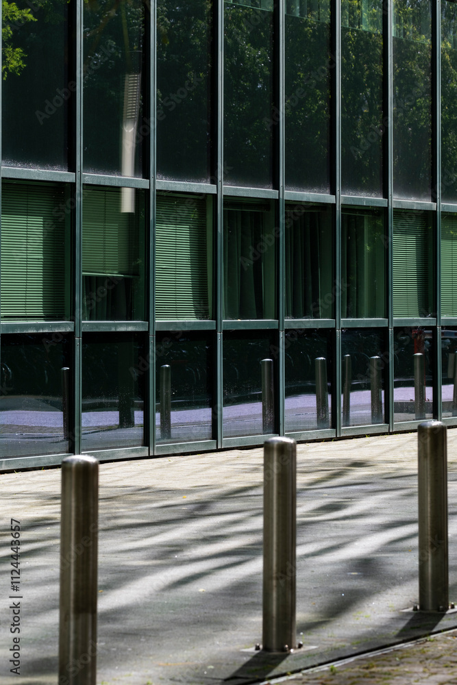 A close-up of a reflective glass facade revealing natural light and ...